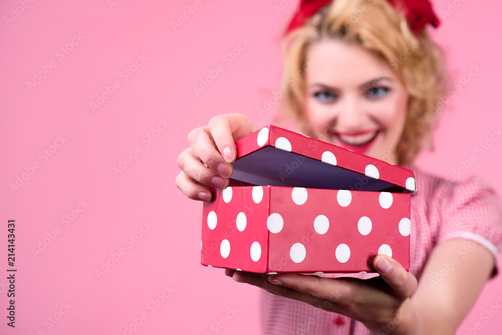Happy woman in pin-up style holding gift box. Beautiful blonde pin-up ...