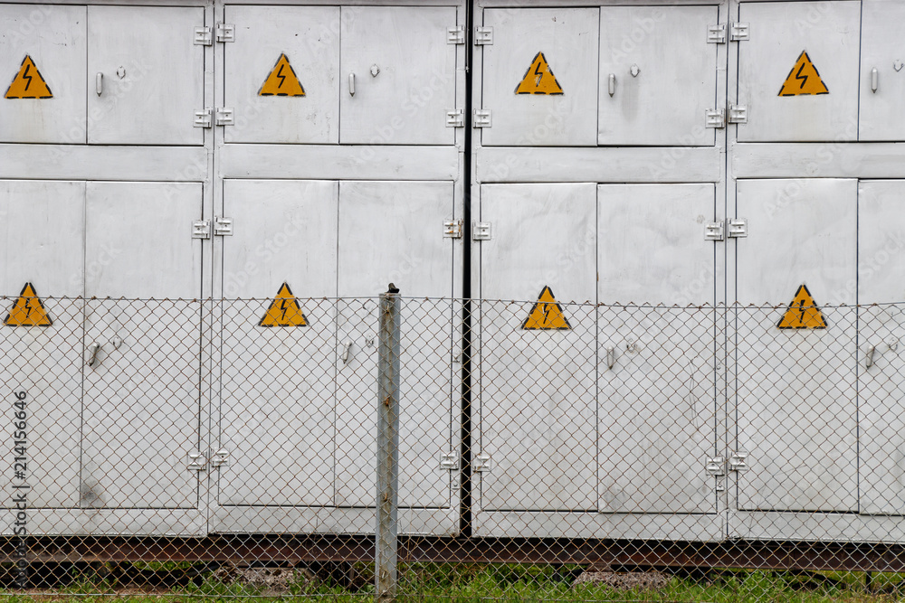 Railway electrical substation. On the doors signs, caution voltage. The ...