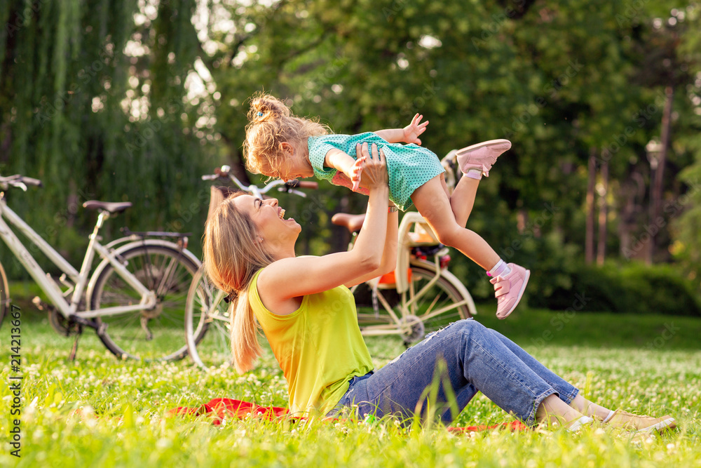 family, happiness, childhood and people concept - Young mother raising ...