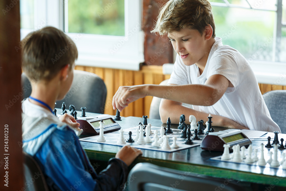 cute handsome boy in white tshirt plays chess with his rival in chess ...