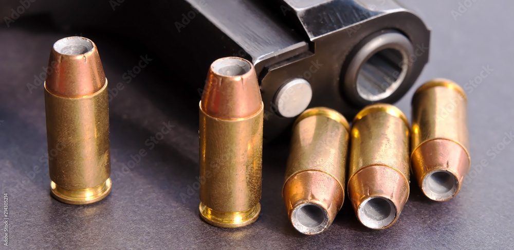 Five 40 caliber hollow point bullets shown next to the muzzle of a ...