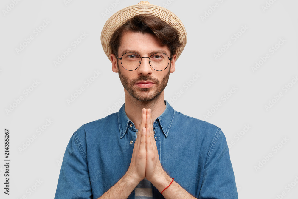 Indoor shot of serious unshaven male with calm facial expression ...