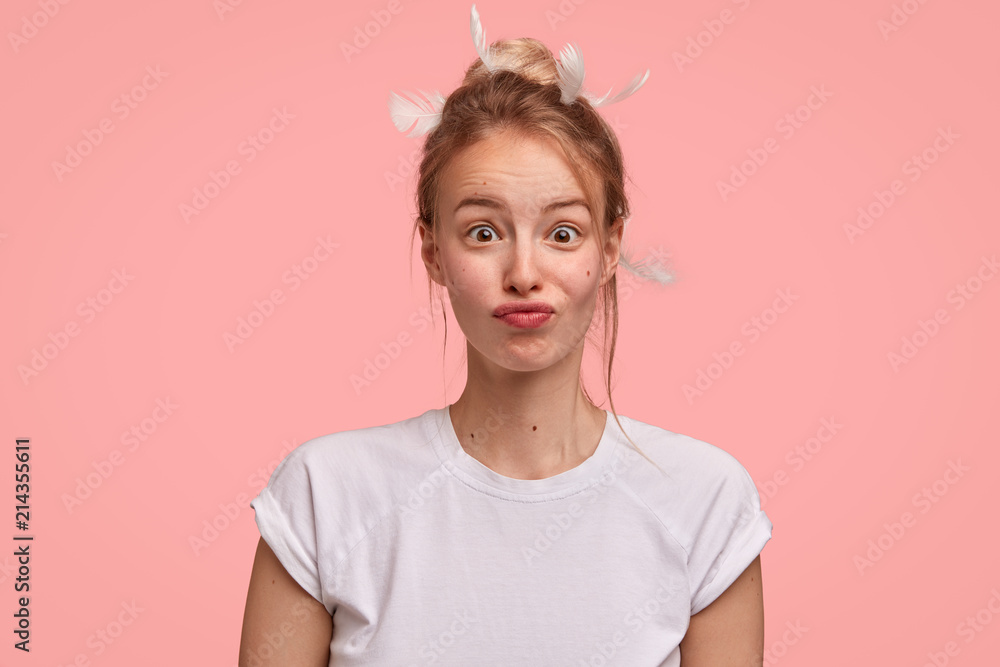 Lovely Caucasian female with surprised expression, makes grimace ...