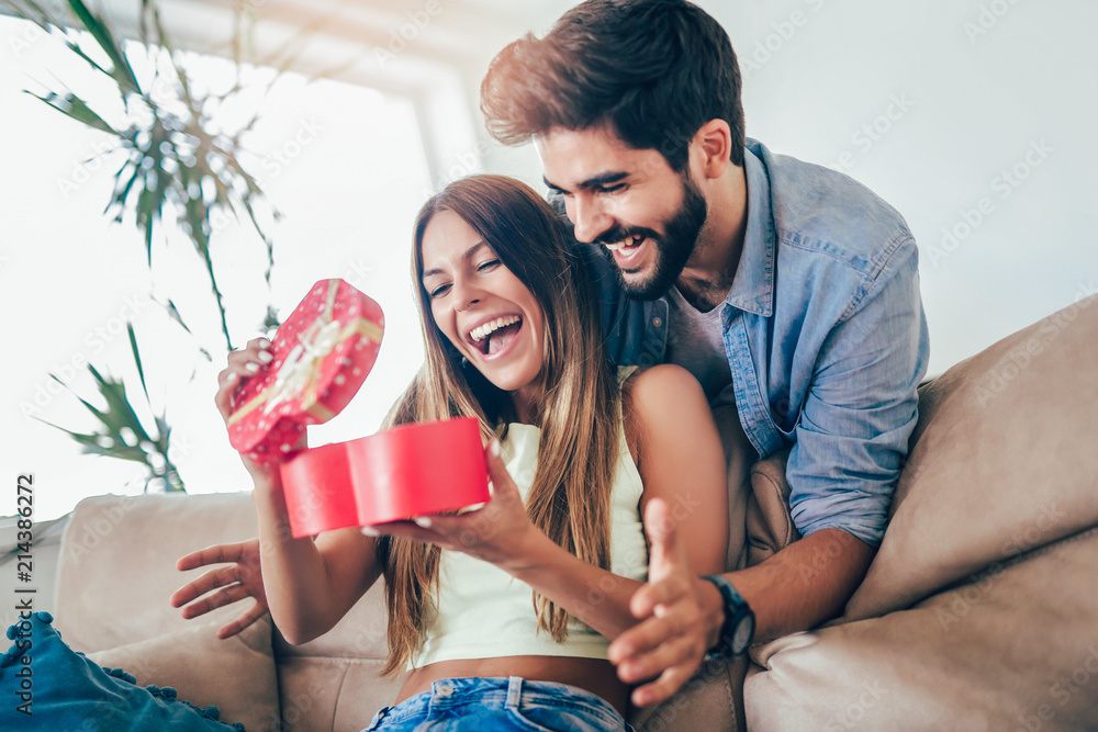 Man giving a surprise gift to woman at home Stock Photo | Adobe Stock