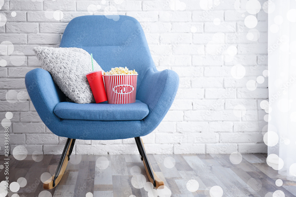 Rocking chair with popcorn and drink in home cinema. Blurred lights in ...