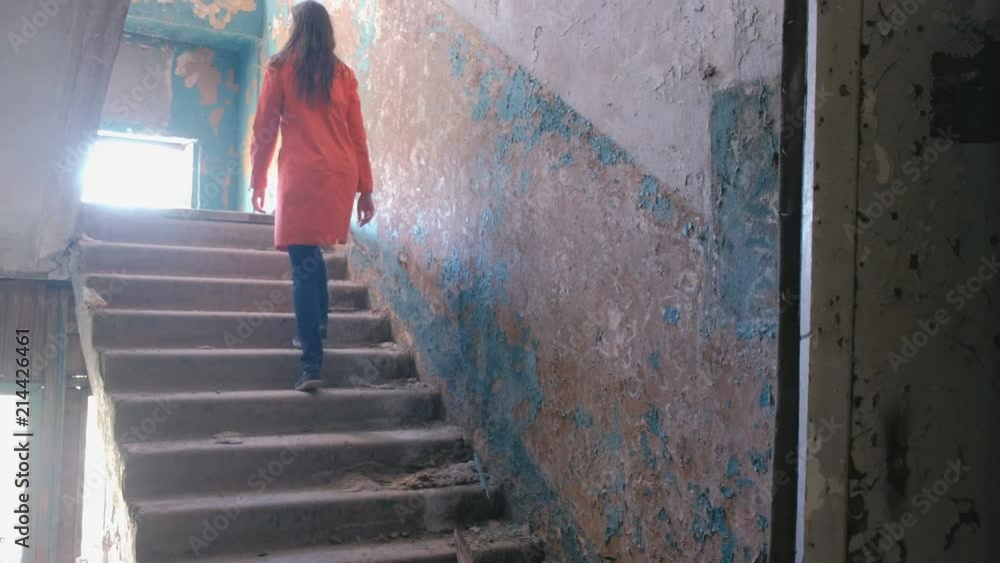Woman in a red cloak inspects destroyed building after the disaster ...