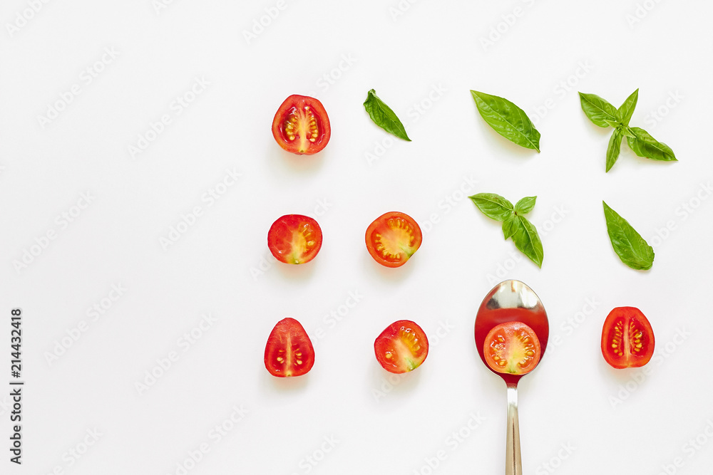 Red cherry tomato, green basil leaves and spoon on white background ...