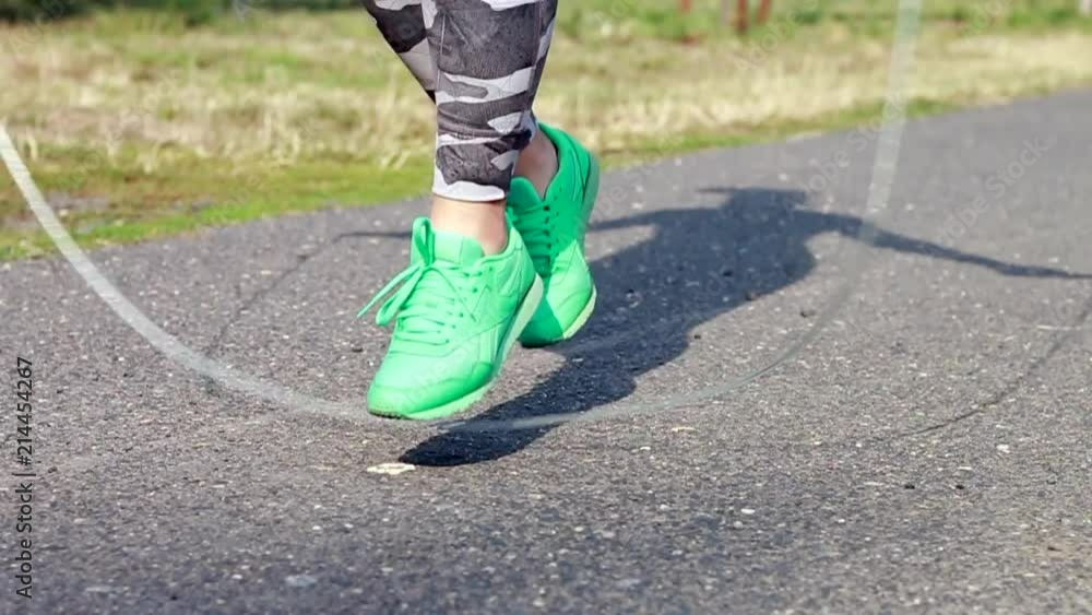 Girl jumping rope. Alternate single leg. Close-up video of feet in ...