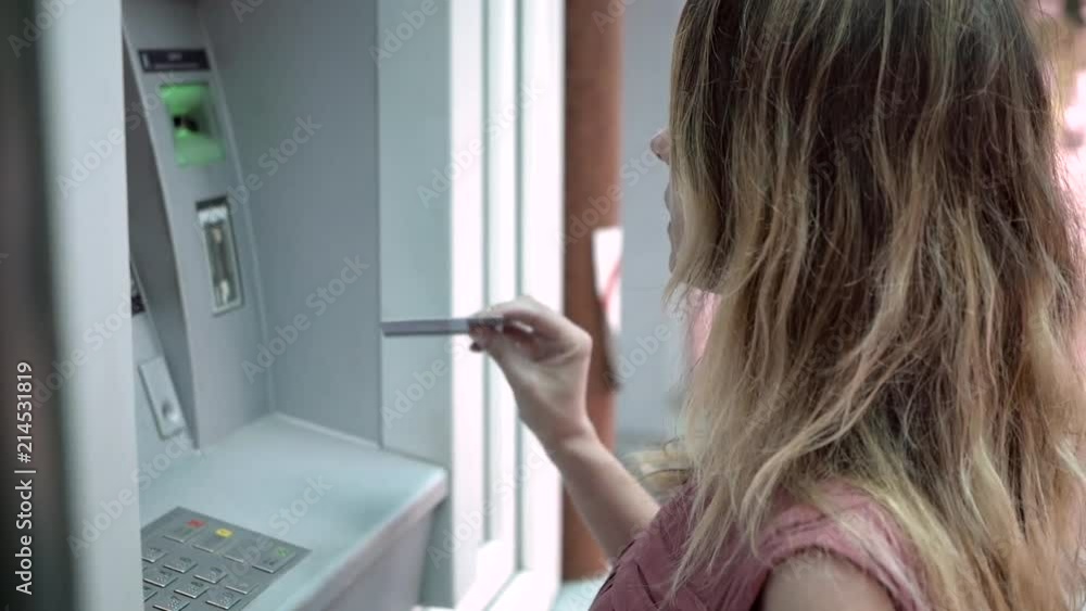 Girl inserts a card into an ATM machine Stock Video | Adobe Stock
