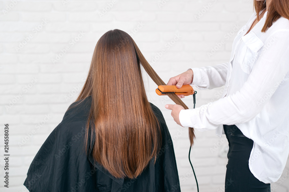 Model sitting while hairstyling in beaty salon with white brick walls ...