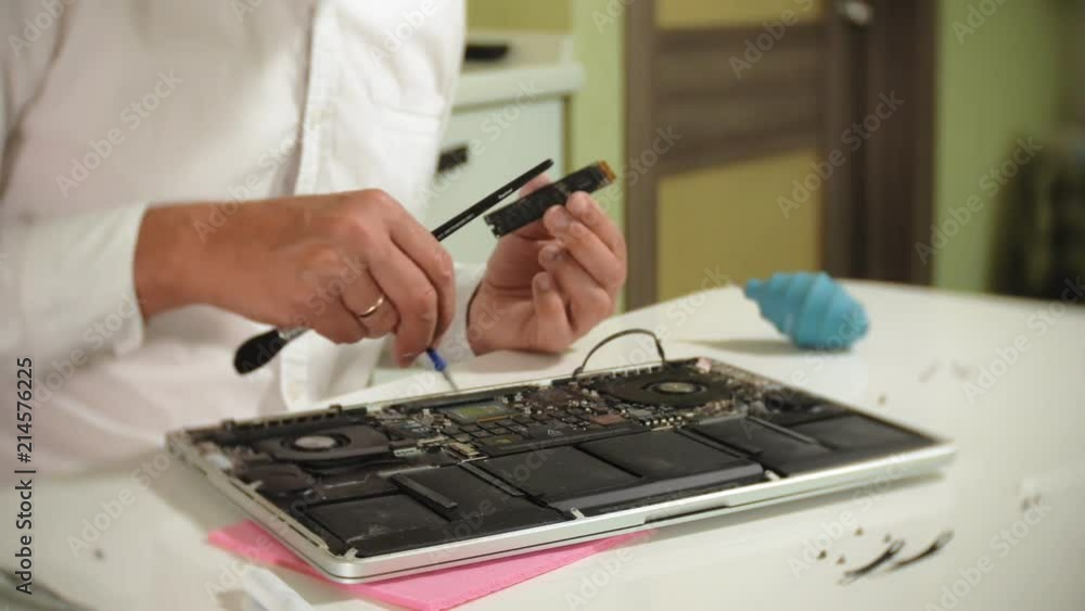 A man is repairing a laptop. The concept of computer repair. Close up ...