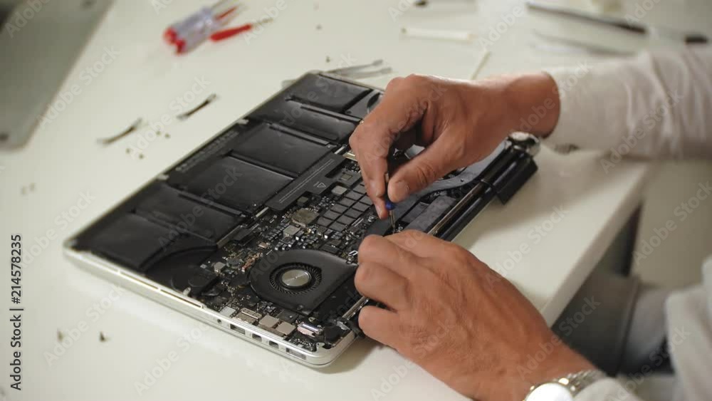 A man is repairing a laptop. The concept of computer repair. Close up ...