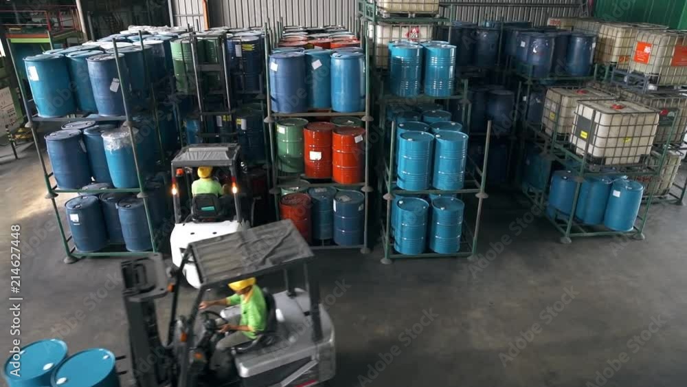 Fork-Lift Carrying 3 Barrels Passing Through Shelves Filled With ...