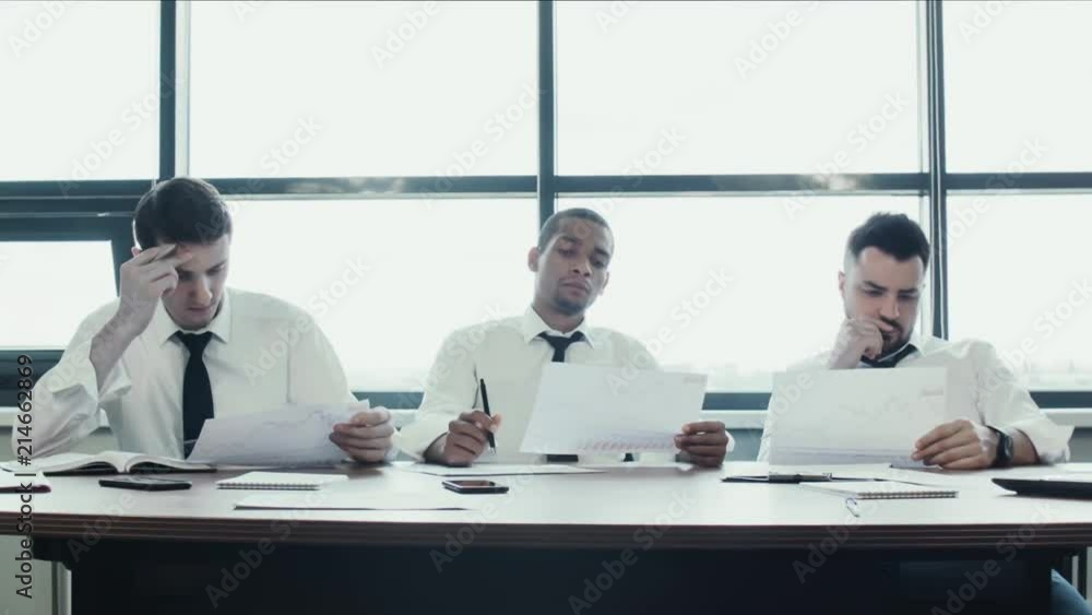 Team of three businessmen in shirts, two caucasian and one african ...