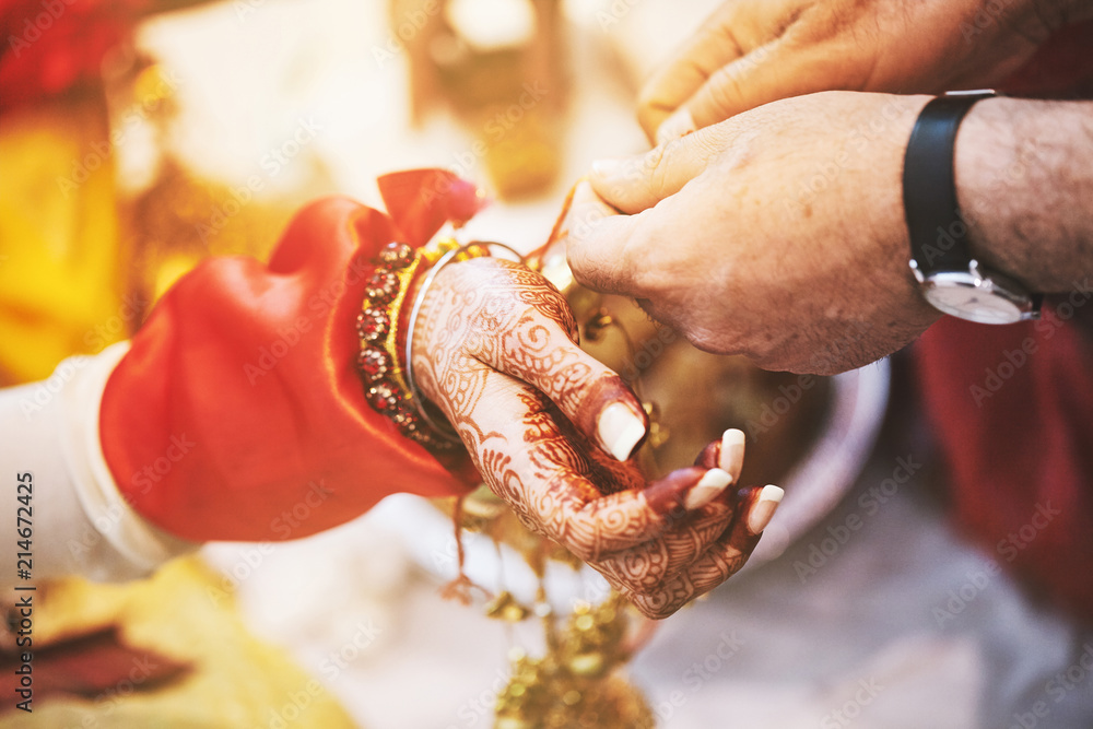 Indian bride ties with holy thread on her wrist at ceremony focus on ...