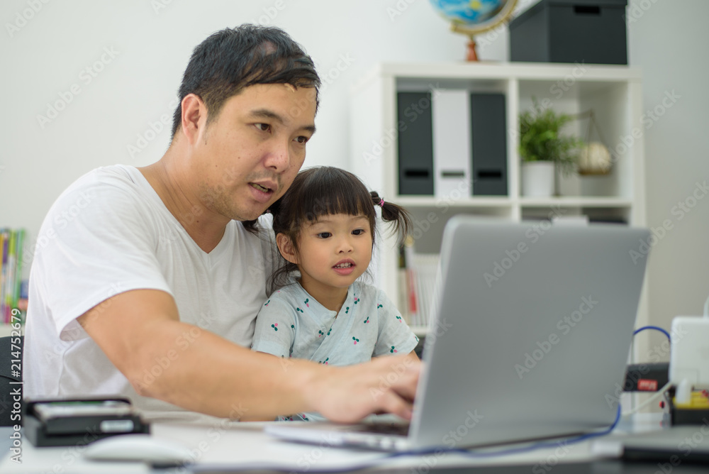 Man holding the kid at the laptop, dad hugs a daughter, Asian family ...