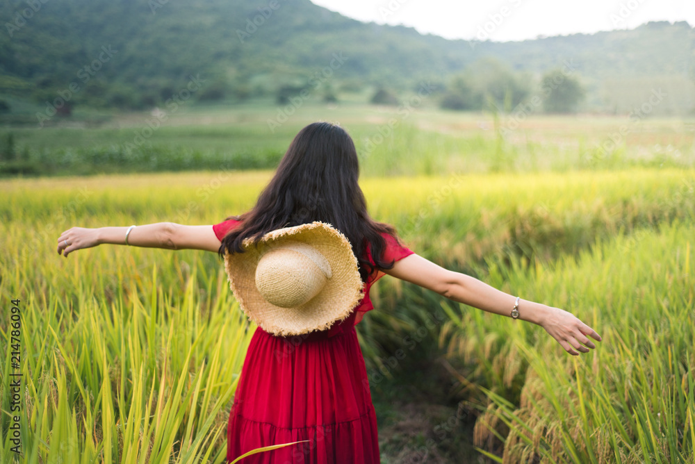 Girl walking in a rice field wearing red dress Stock Photo | Adobe Stock