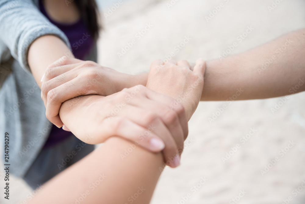 Three people join hands together on white sand beach background ...
