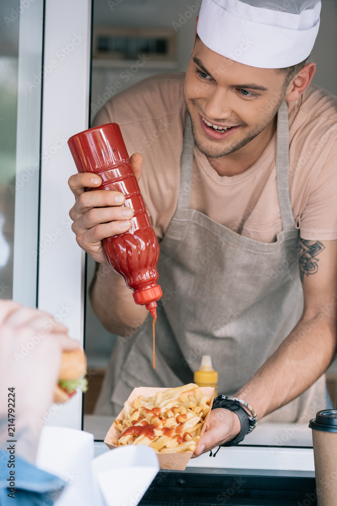 smiling chef adding ketchup to hot dog in food truck Stock Photo ...