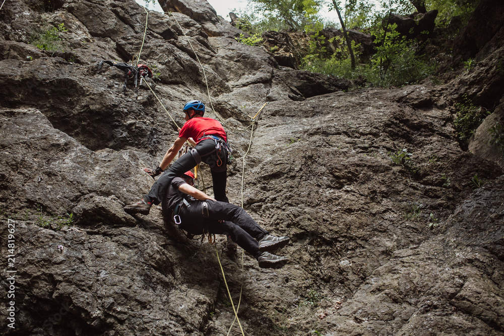 Mountain rescuer helping injured climber Stock Photo | Adobe Stock