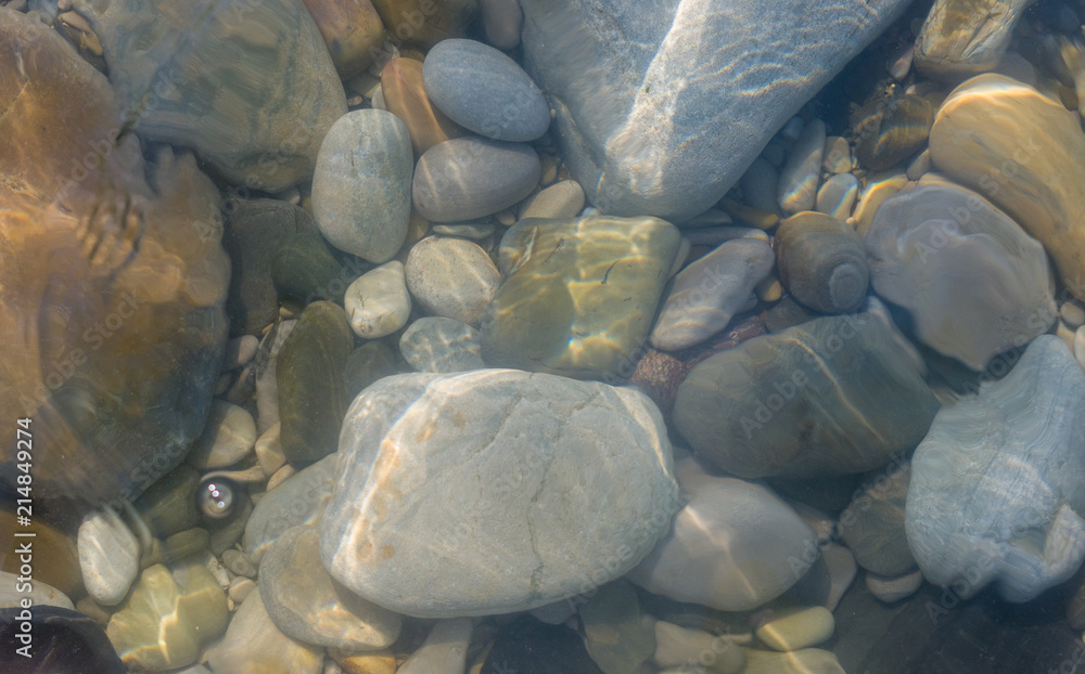 pebble stones on the sea beach, the rolling waves of the sea with foam ...
