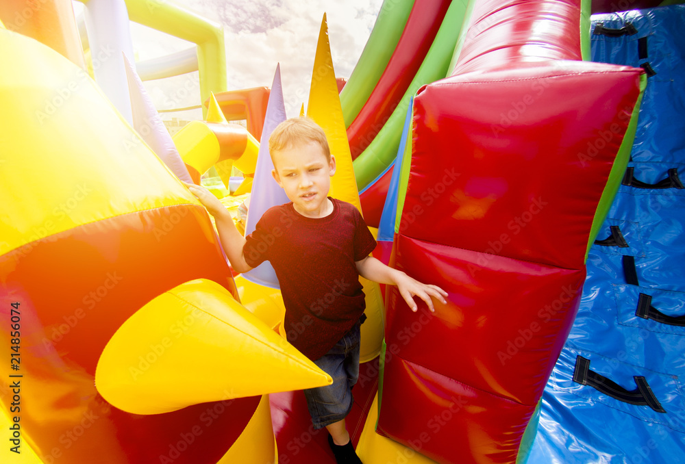 Foto de Child jumping on colorful playground trampoline. Kids jump in ...