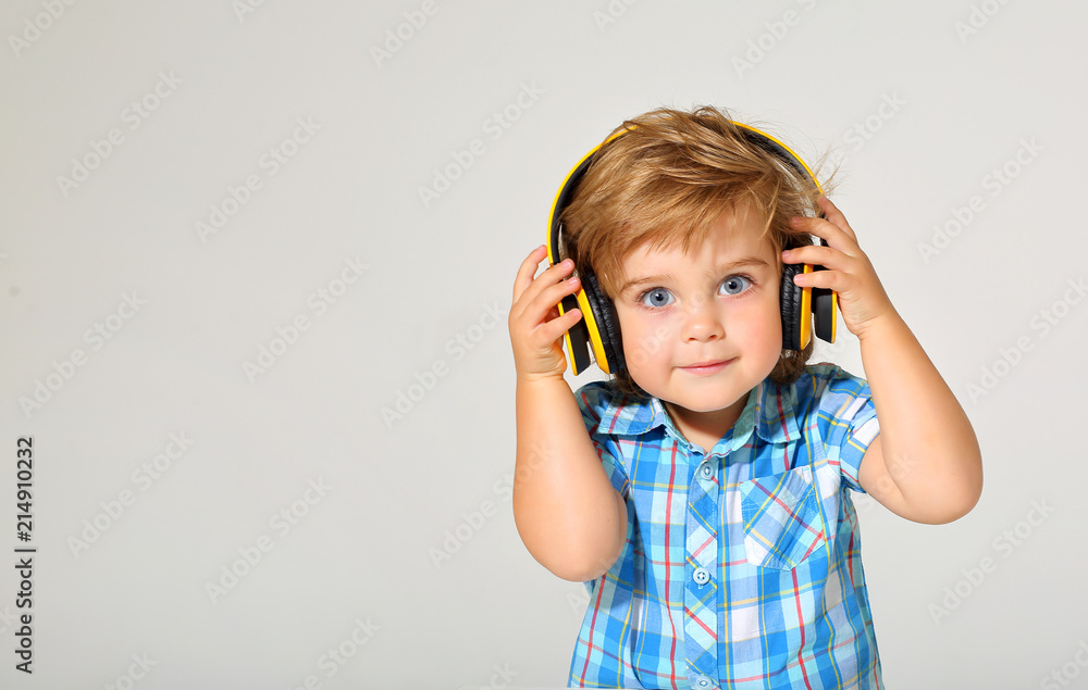 Charming boy listening to music in yellow headphones Stock Photo ...