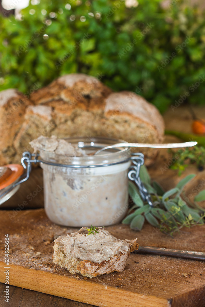 Rustic pâté\pate made from pork liver in a glass jar and a slice of ...