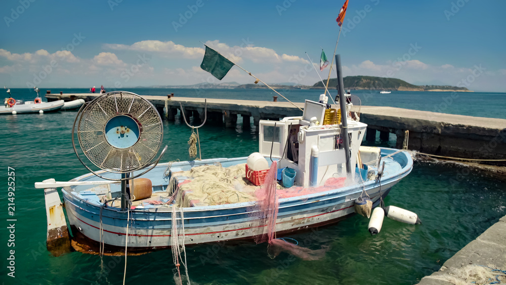 Old fishing vessel with drift nets parked near pier and floating on ...