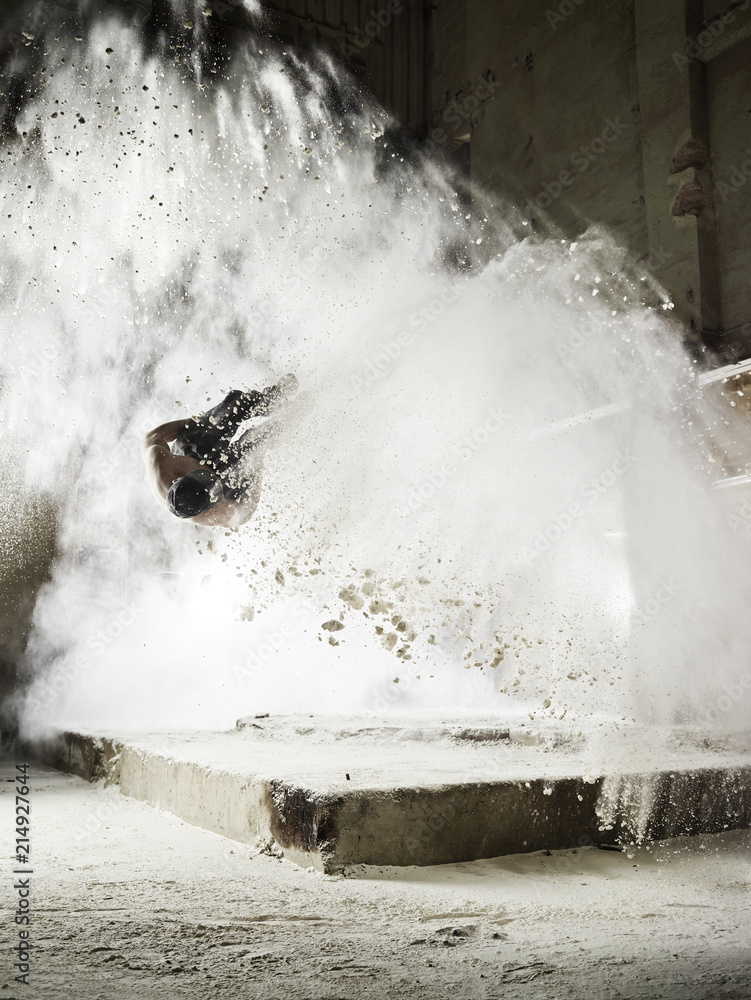 Man jumping in flour dust cloud during free running exercise Stock ...