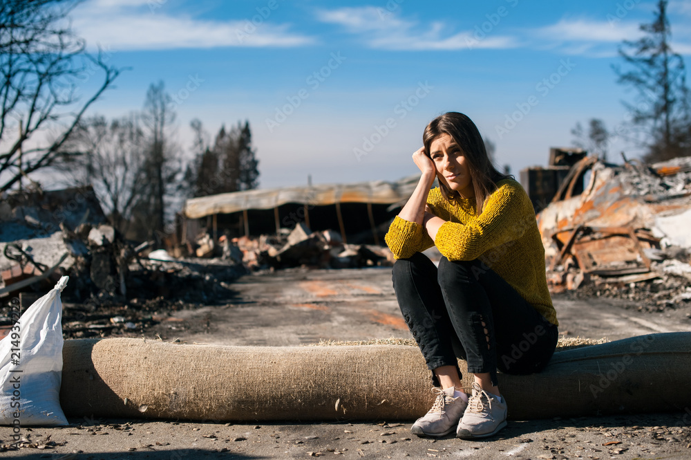 Sad woman home owner holds his head by hand checking burnt out house ...