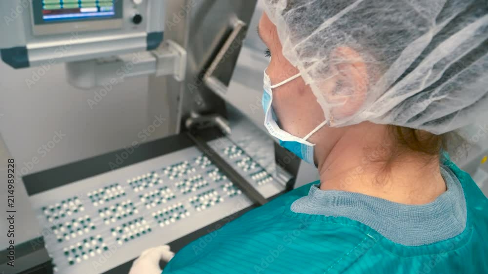 Worker control the process of sorting capsules into packages at ...