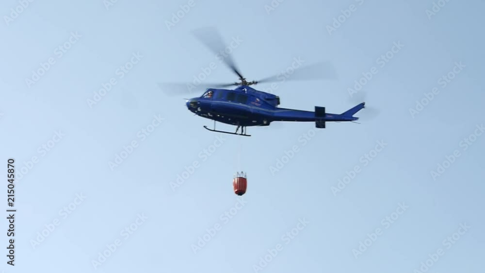 The fire brigade rescue helicopter carries water in the tank. Stock ...
