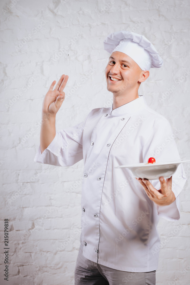 Smiling chef preparing an Italian dish of pasta with satisfaction ...