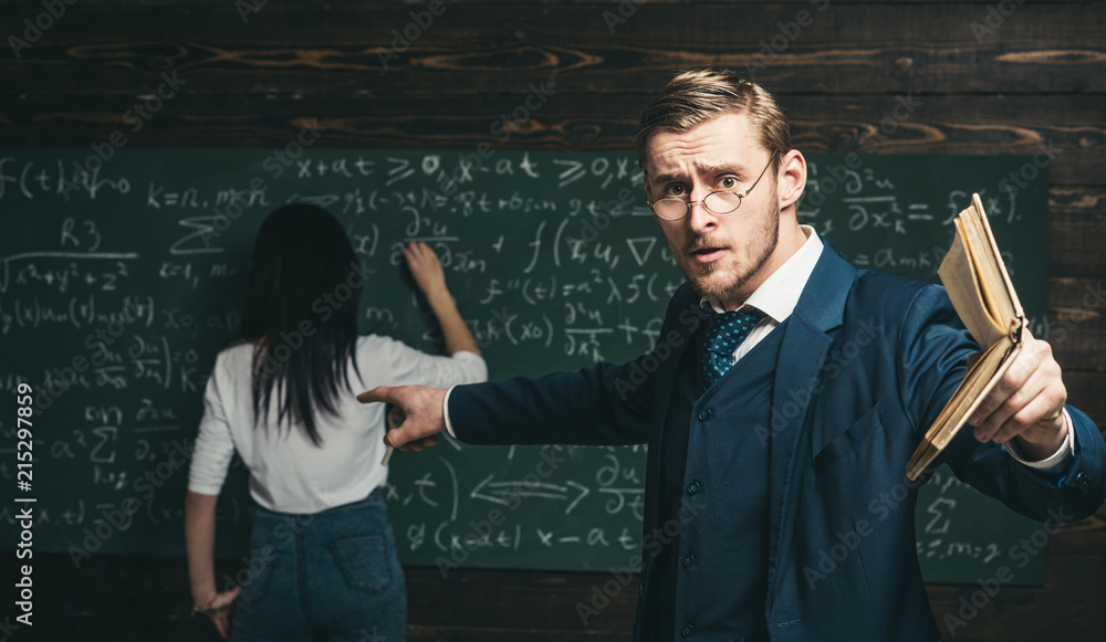 Agitated young professor with stylish mustache and beard pointing book ...