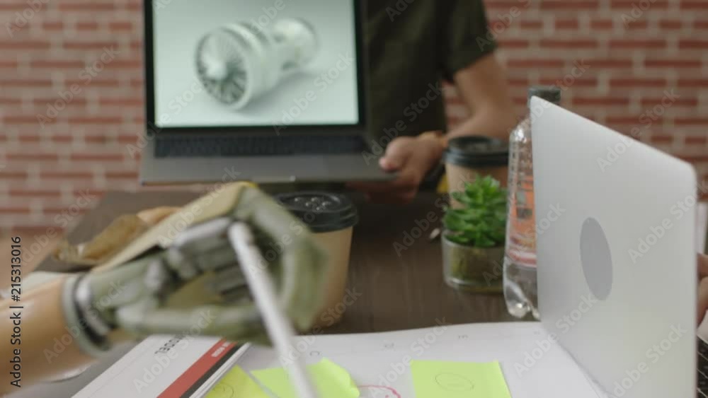close up prosthetic arm creative group of business people engineers ...
