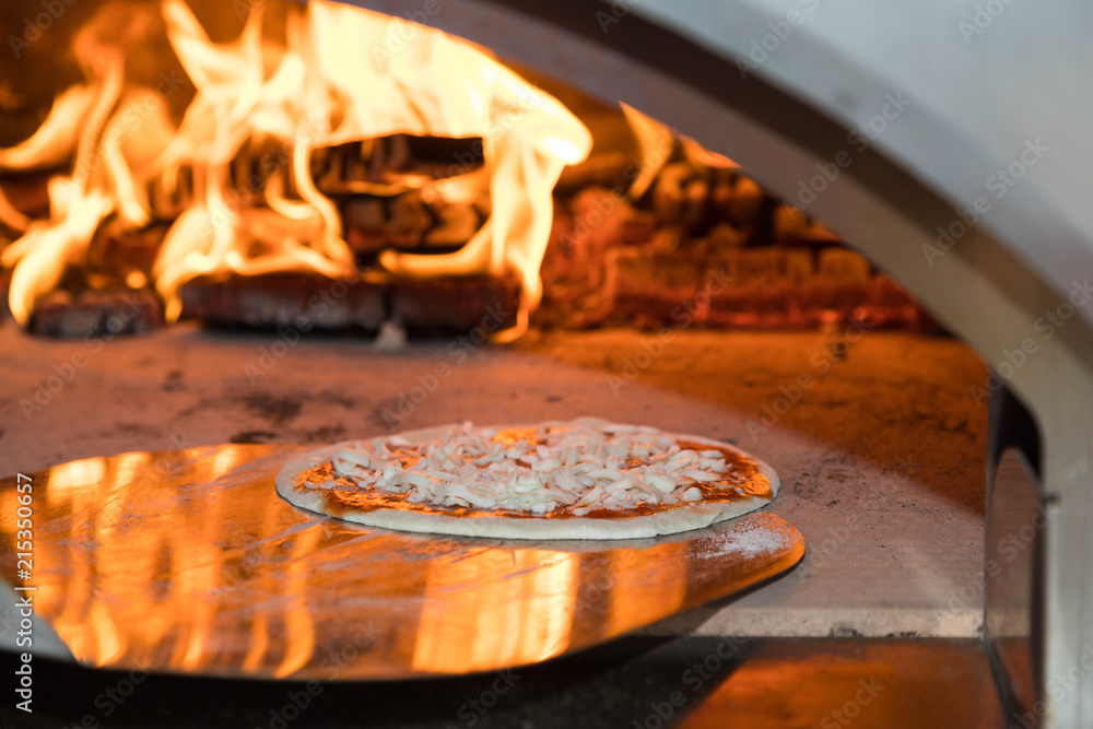 The working furnace for preparation of pizza. Inside burns firewood and ...