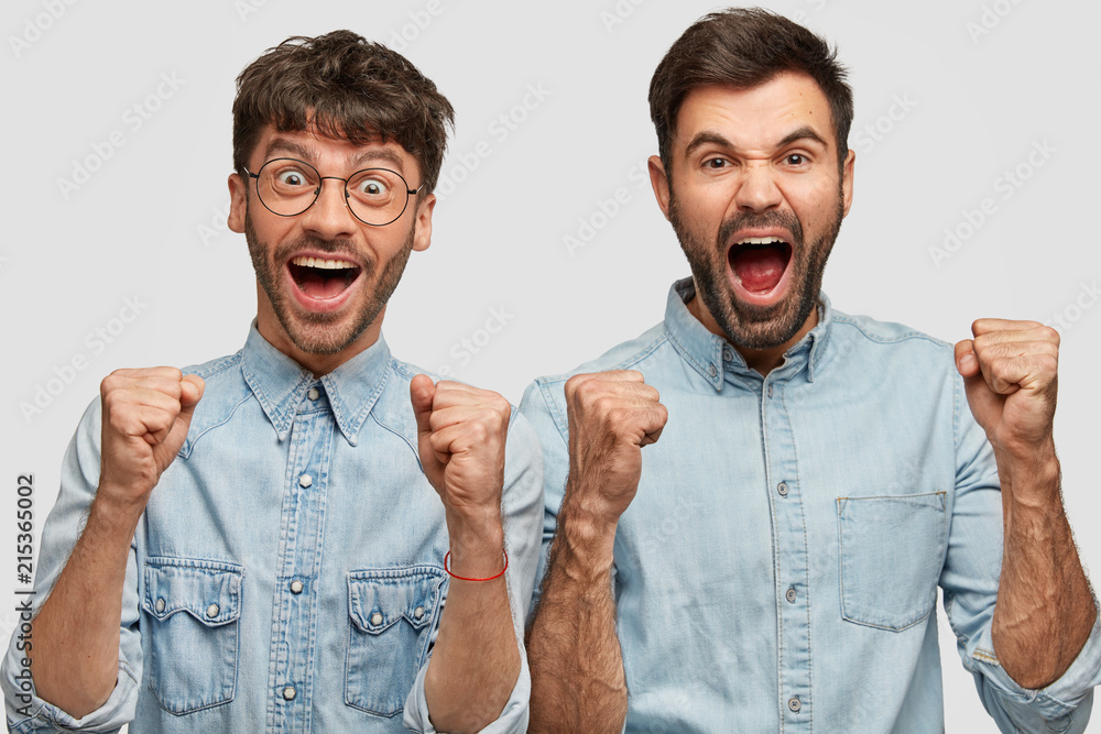 Glad male football fans shout for their favourite team, clench fists ...