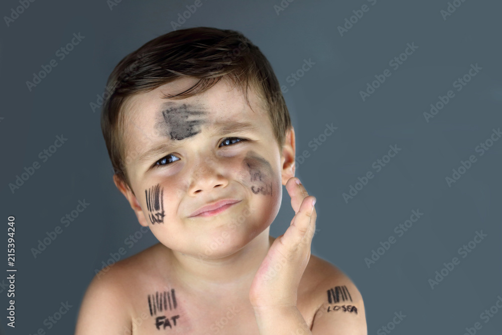 sad child who suffer bullying with bar code and insults in his face ...