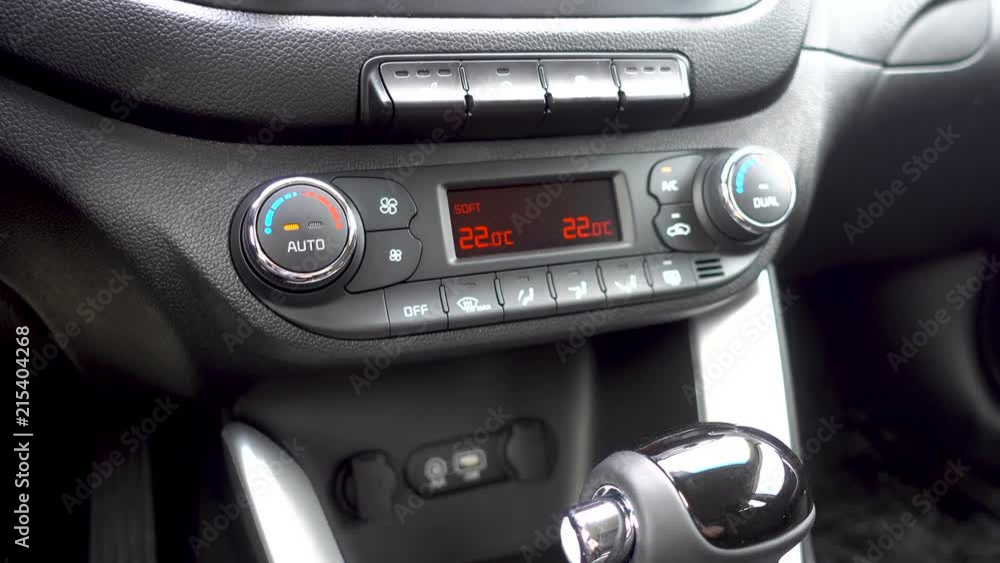 Closeup of hand adjusting the air conditioner button in the car. Man ...