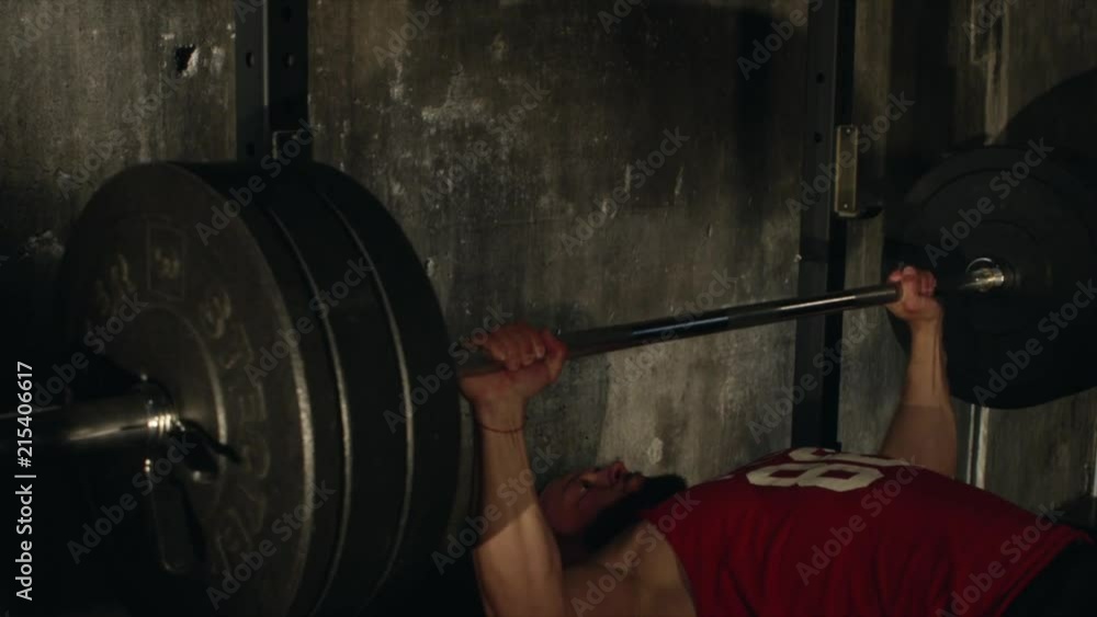 Big bearded man bench pressing the barbell. Muscular man pumping chest ...