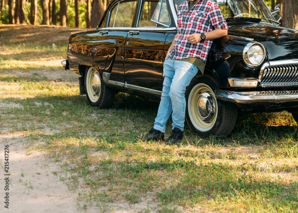 Handsome man standing in front of car.hand is a black watch. waiting ...