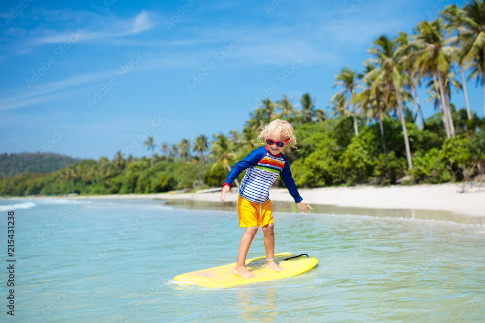 Child surfing on tropical beach. Surfer in ocean. Stock-Foto | Adobe Stock
