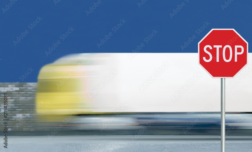 Red stop road sign, motion blurred truck vehicle traffic background ...