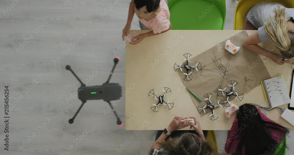 young group of diverse student girls building drones together smart ...