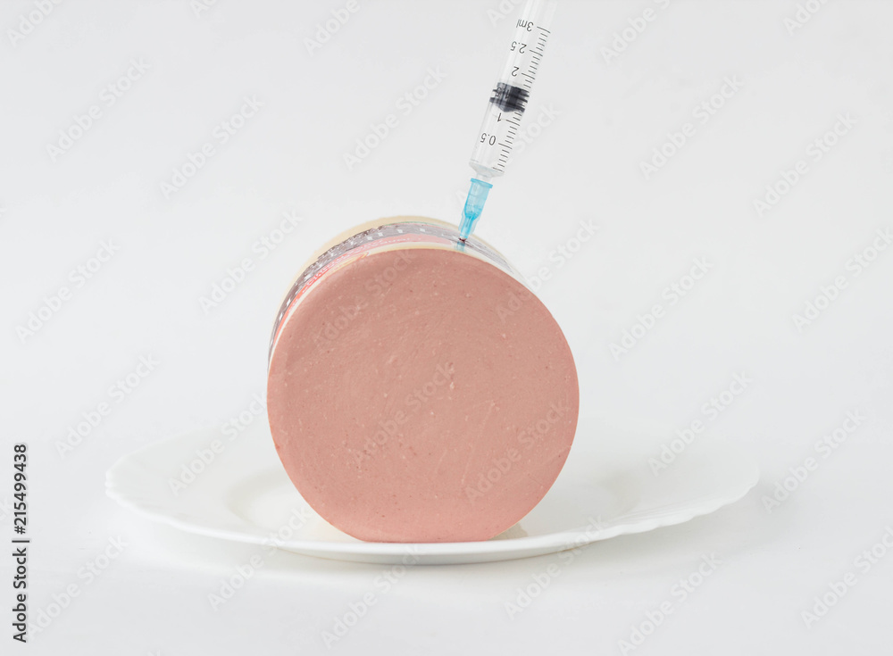 Cooked sausage on a white background into which preservatives and ...