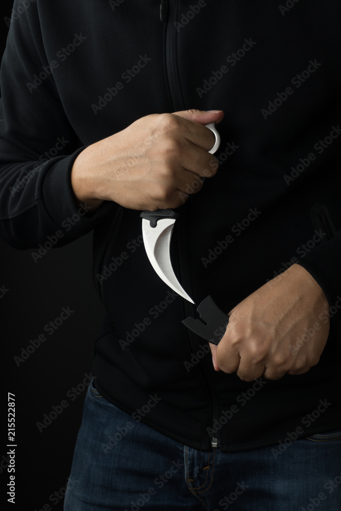 combat and violence concept, a man pulling out a karambit knife Stock ...