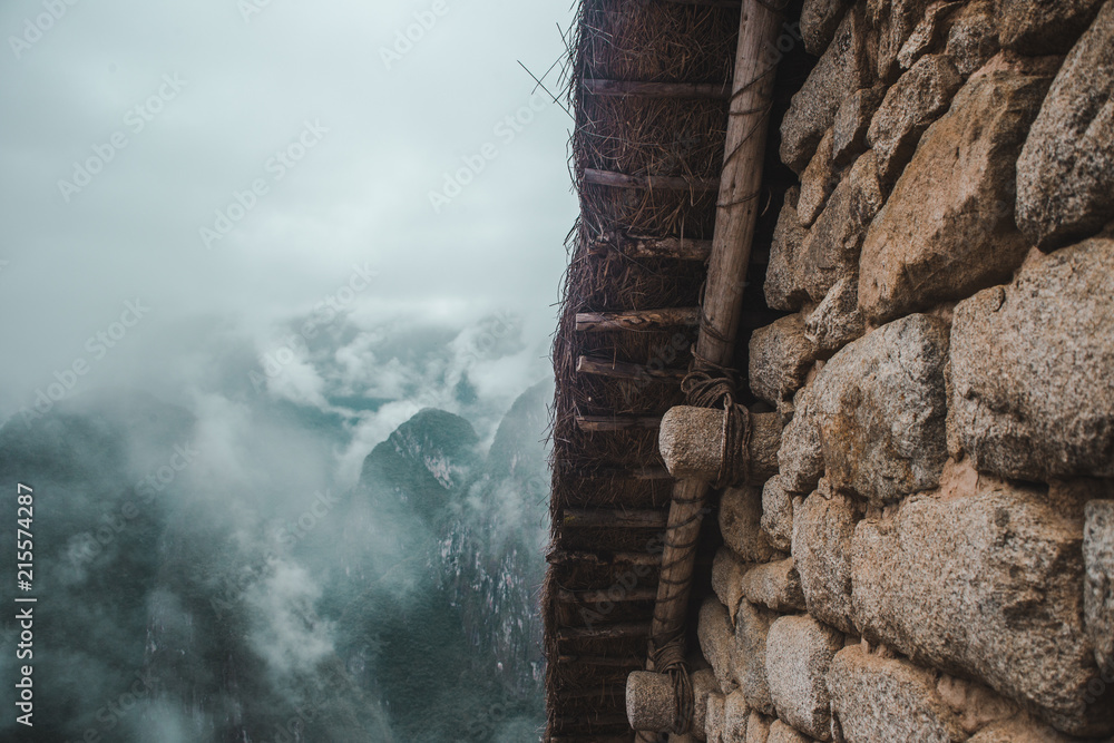 Perfectly preserved ancient stone Inca house with straw roof and blue ...