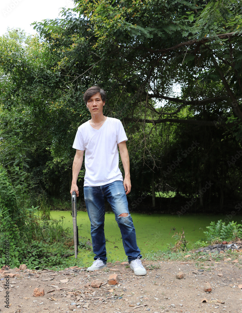 The gunner man holding long gun in hand with white shirt and denim jean ...