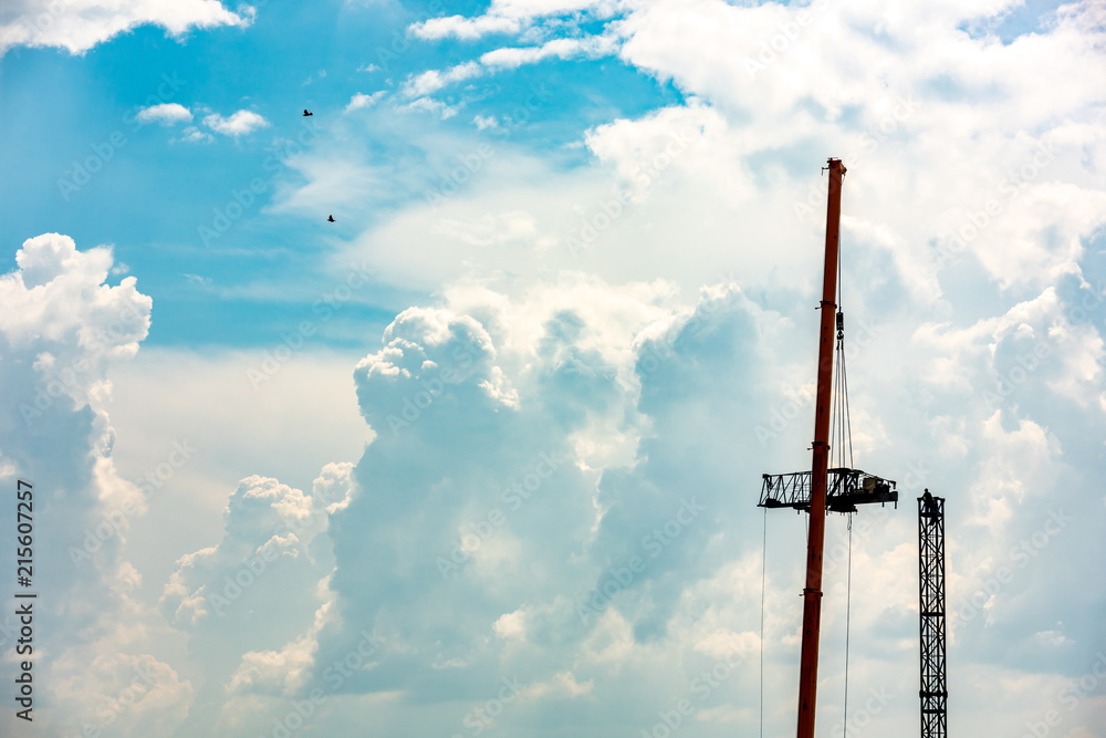 Setting up a blue tower crane in the construction site with a heavy ...